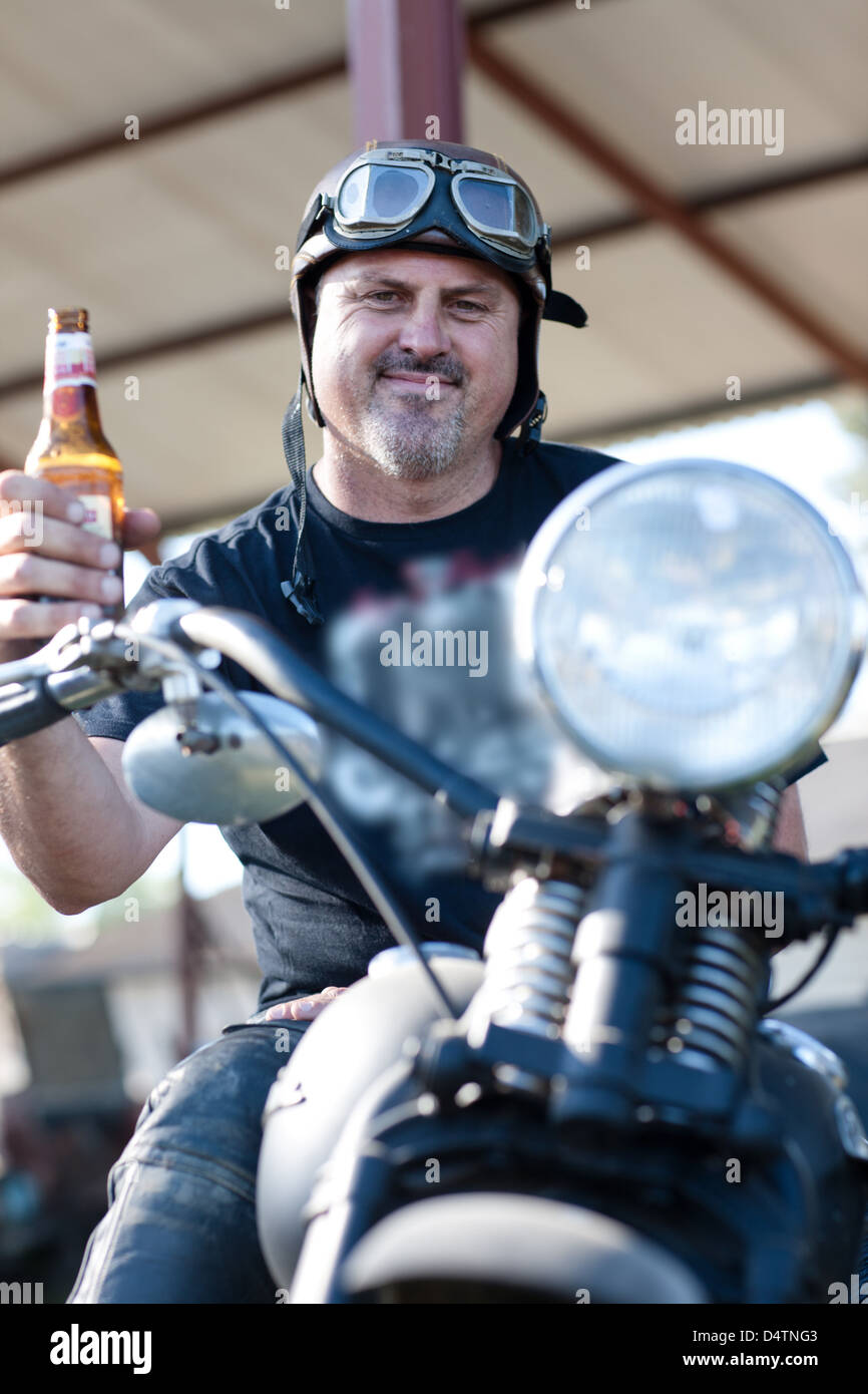 Man drinking beer on motorcycle Stock Photo - Alamy