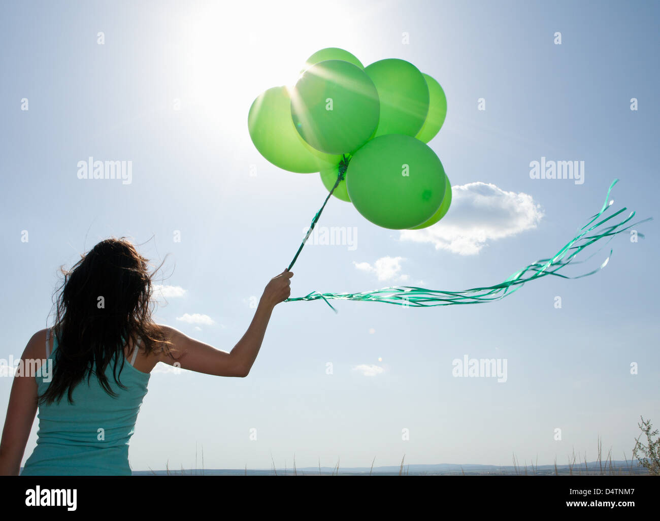 Woman carrying bunch of balloons Stock Photo - Alamy