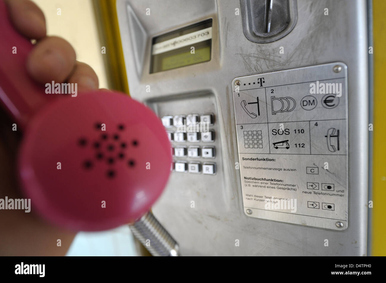 A sign in a phone box lists the emergency telephone codes 110 for the ...