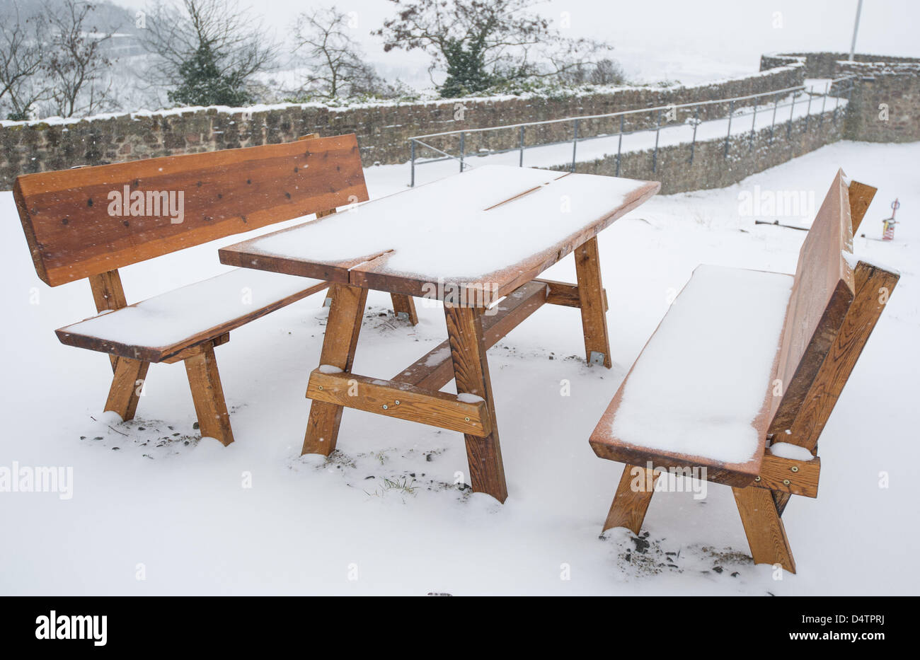 A table and two benches are covered in snow at the Neuleiningen Castle ...
