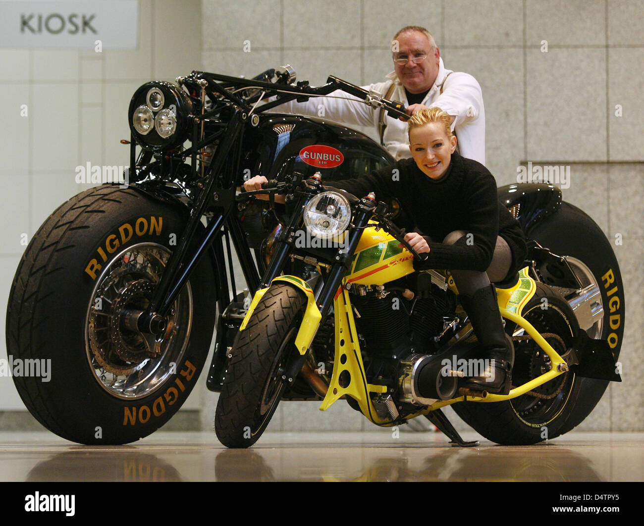 Model Xenia (front) poses on a ?TGS Carrera Bike? in front of a ?Gunbus ...