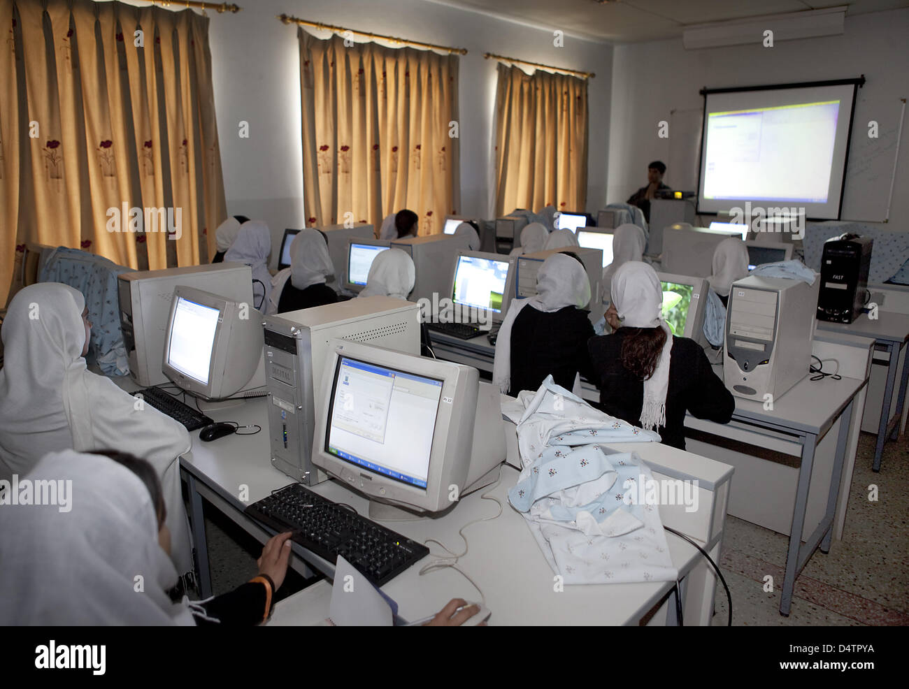 Afghan girls wearing headscarves attend a computer sciences lesson at ...