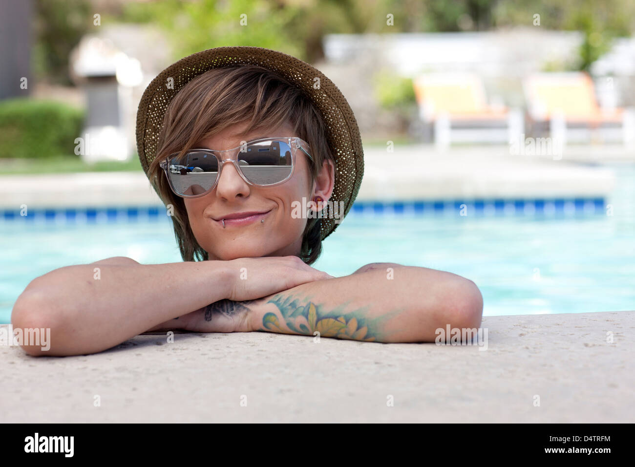 Woman leaning on edge of pool Stock Photo - Alamy