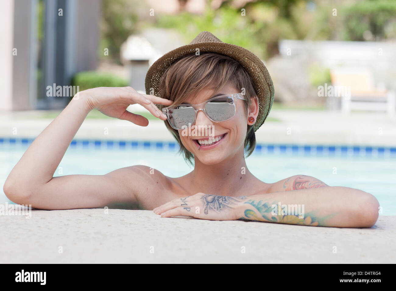 Woman leaning on edge of pool Stock Photo - Alamy