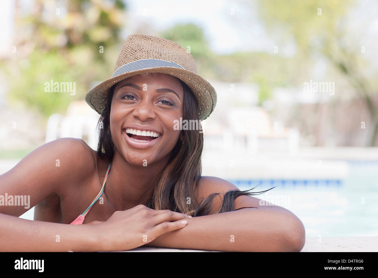 Woman leaning on edge of pool Stock Photo - Alamy