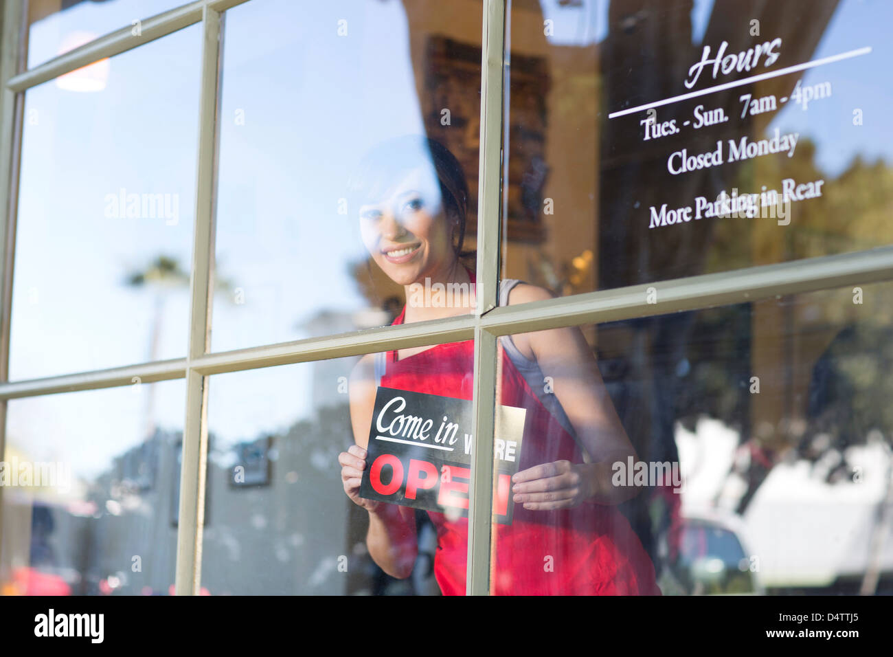 Waitress putting open sign in window Stock Photo - Alamy