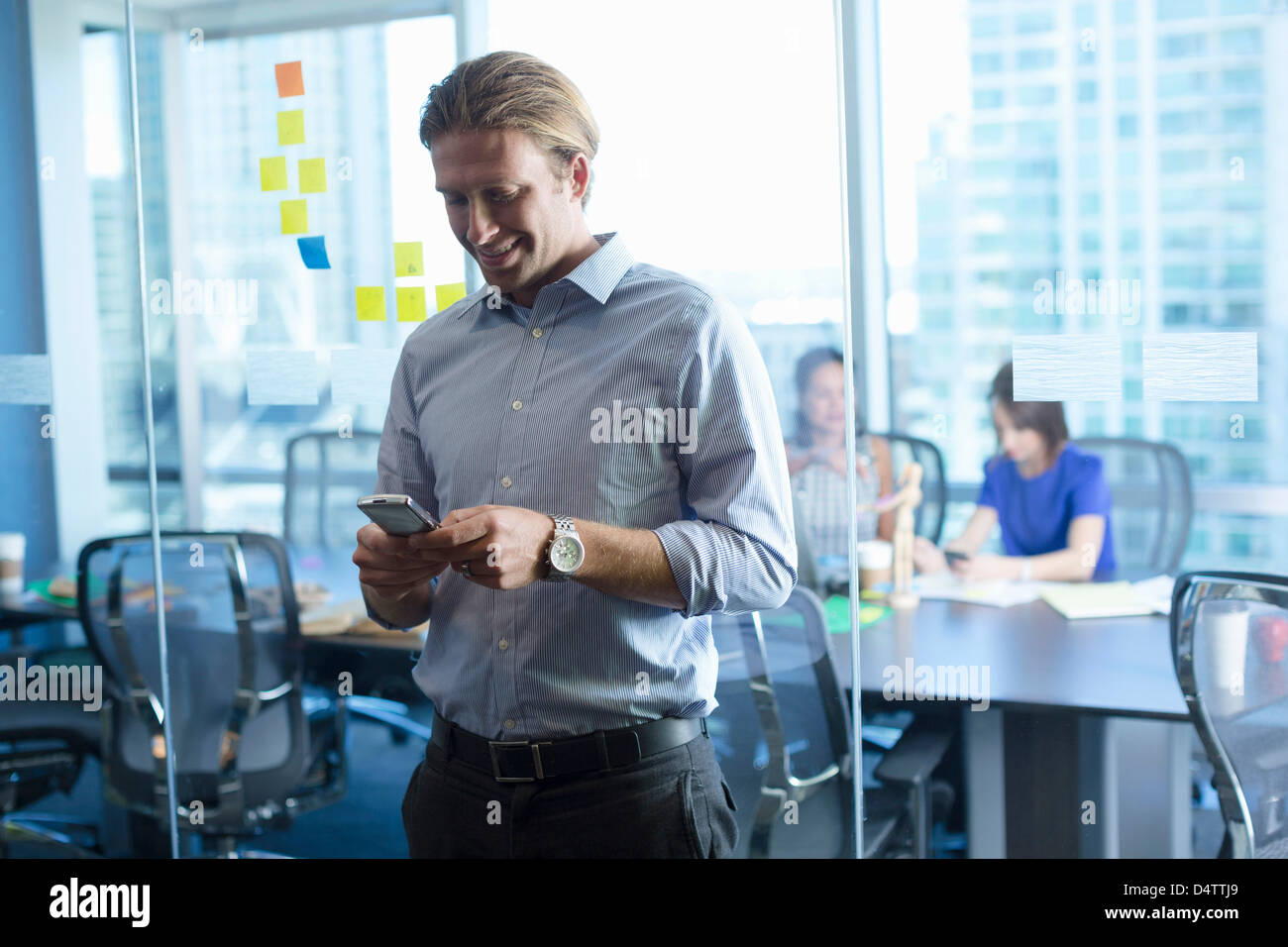 Businessman using cell phone in office Stock Photo - Alamy