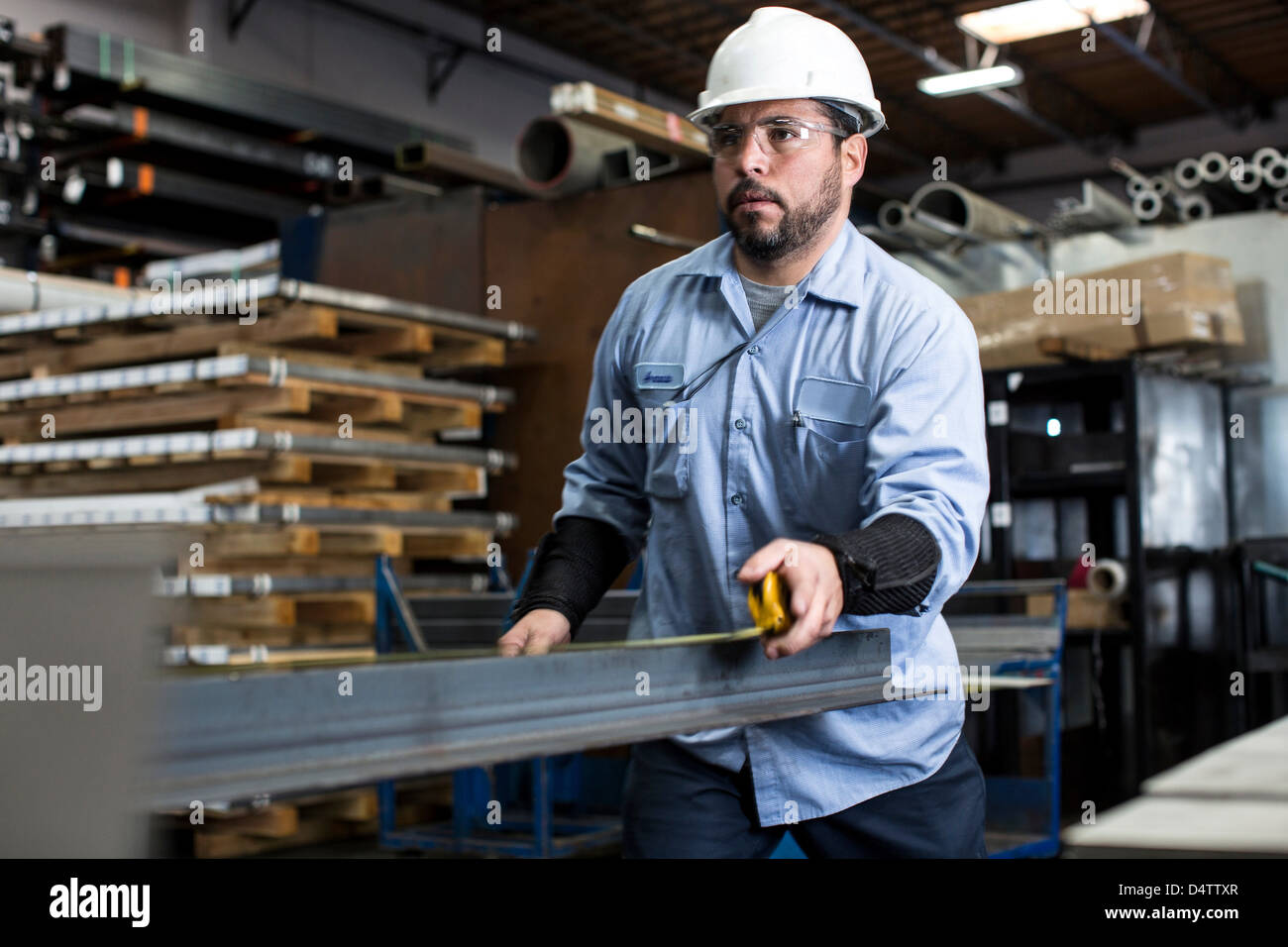 Worker measuring in metal plant Stock Photo - Alamy