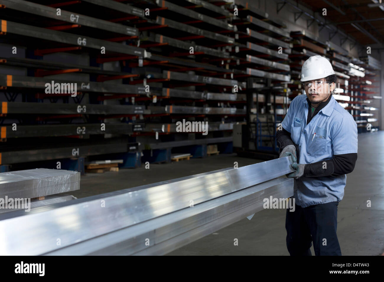 Worker holding metal in plant Stock Photo - Alamy