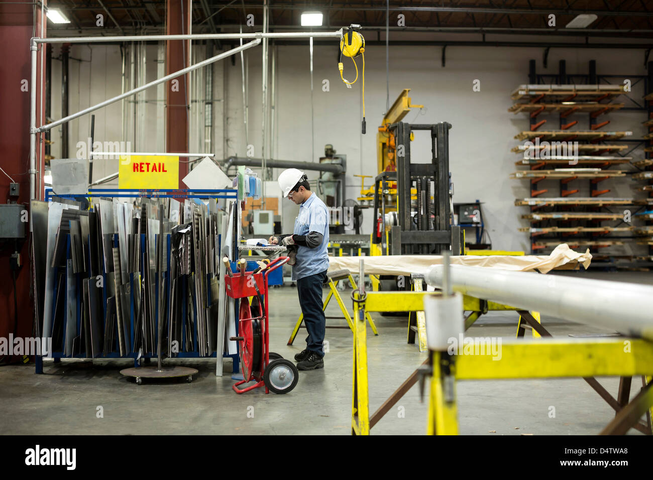 Worker standing in metal plant Stock Photo - Alamy