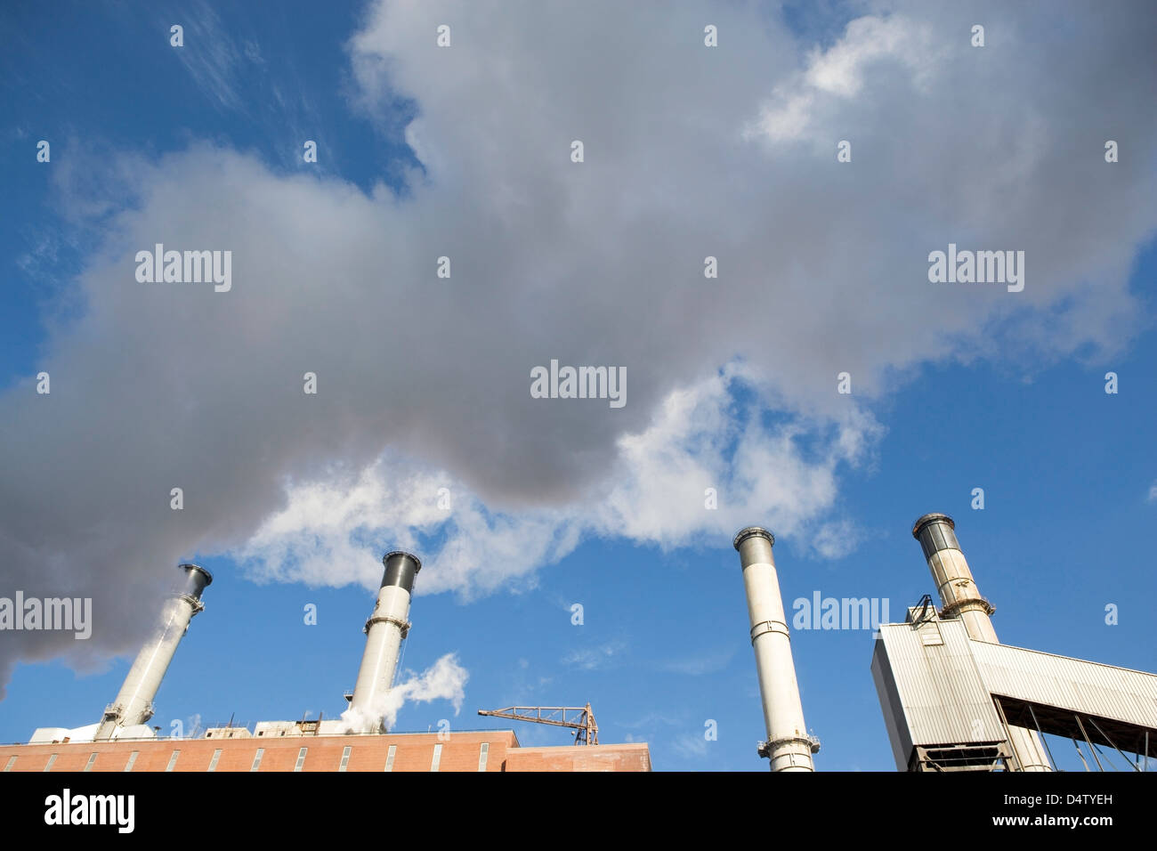 Factory smokestacks against blue sky Stock Photo - Alamy
