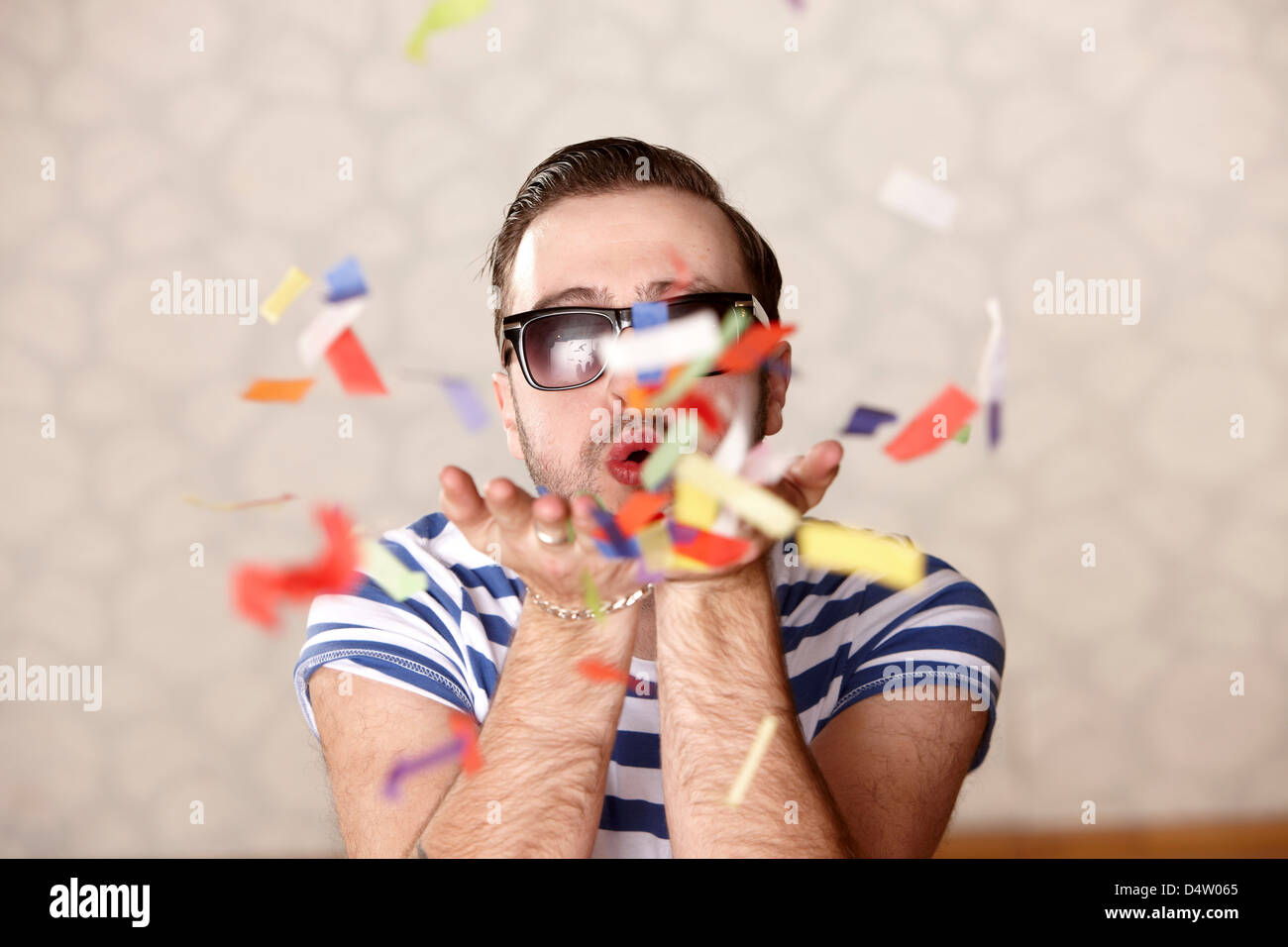 Man blowing confetti at party Stock Photo - Alamy