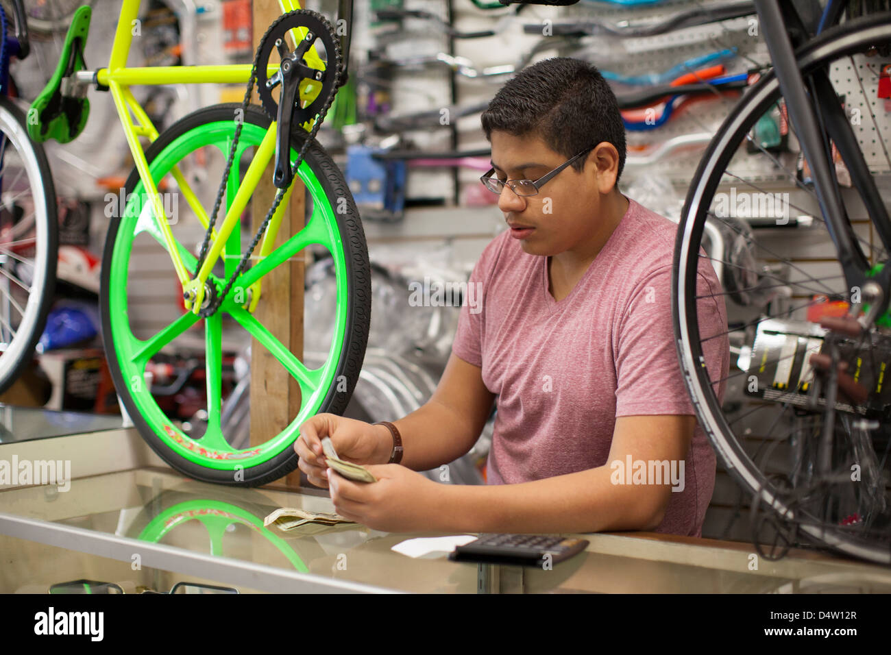 Mechanic counting till in bicycle shop Stock Photo - Alamy