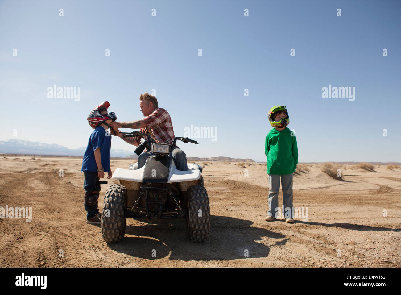 Father and sons on four-wheeler Stock Photo - Alamy