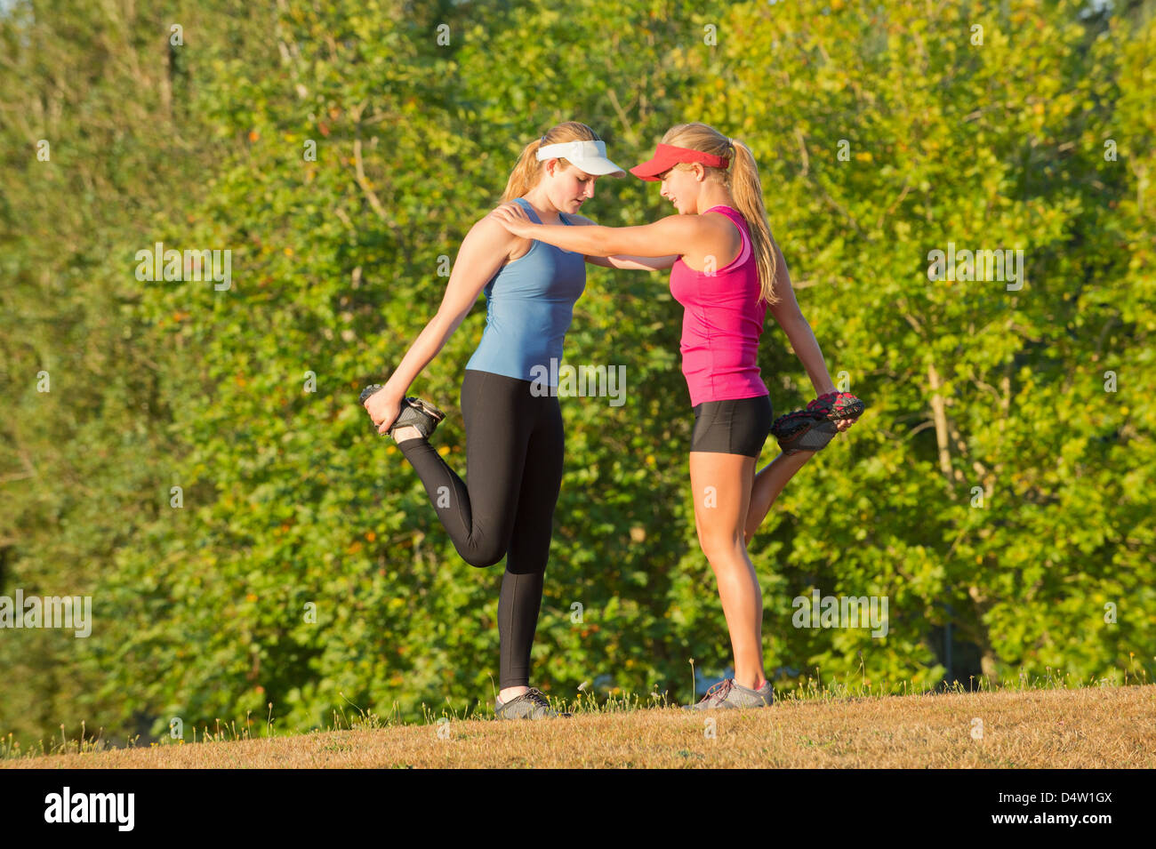Teenage girls stretching in field Stock Photo - Alamy