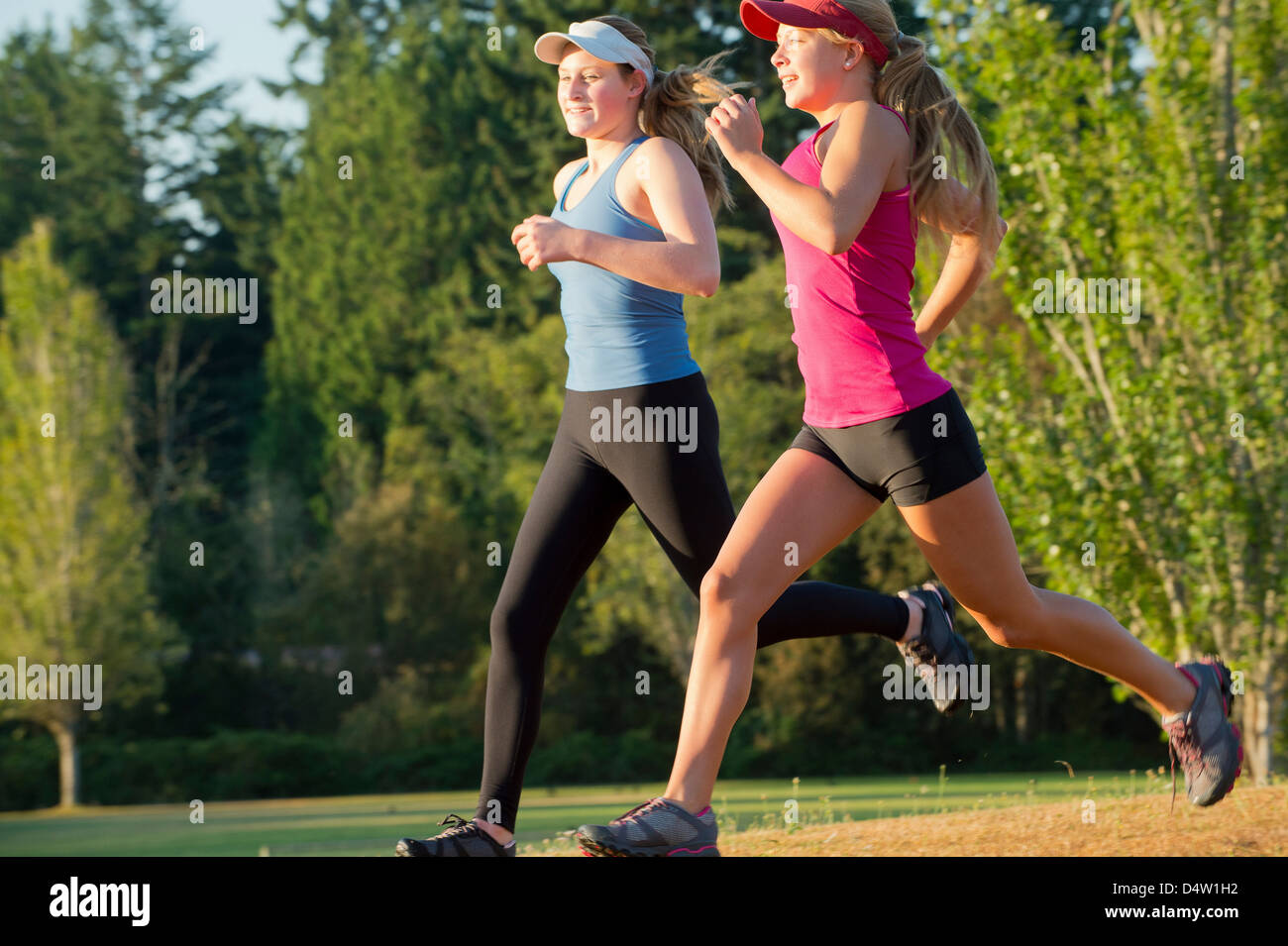 Teenage girls running together in field Stock Photo - Alamy