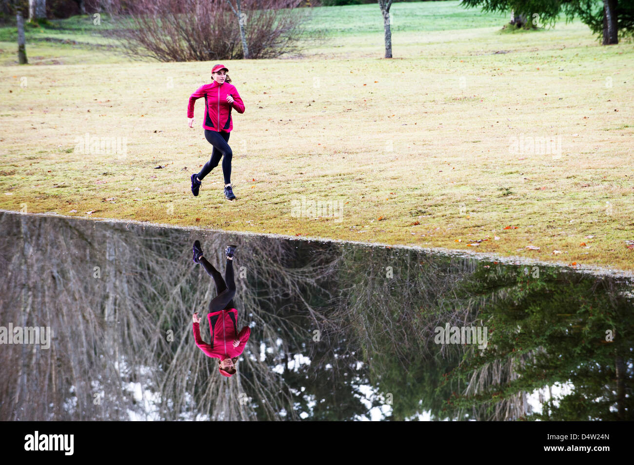 Woman running by still rural lake Stock Photo - Alamy