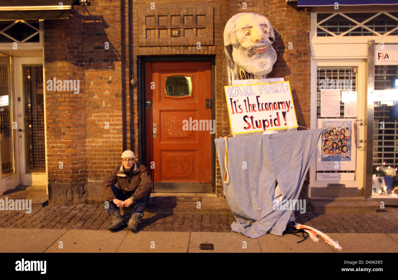 An exhausted climate activist sits next to a figure of Karl Marx during ...