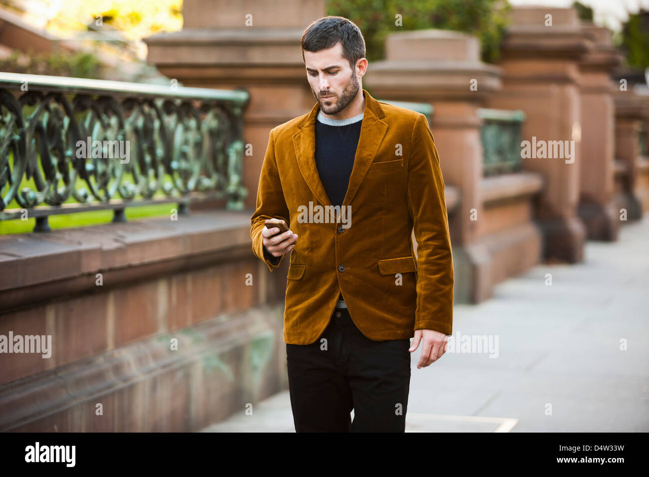Man using cell phone on city street Stock Photo - Alamy