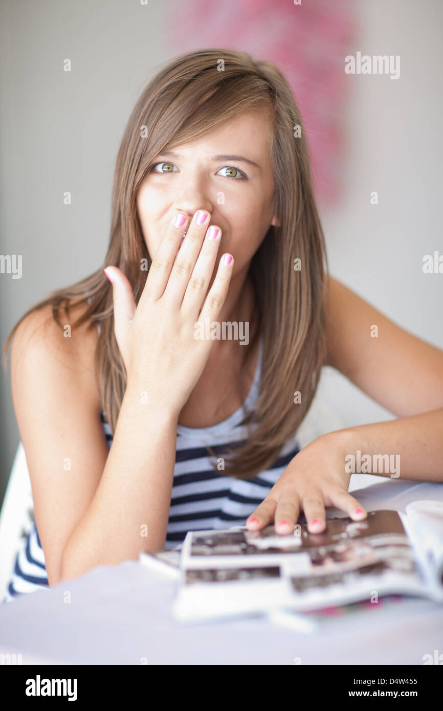 Teenage girl gasping at magazine Stock Photo - Alamy