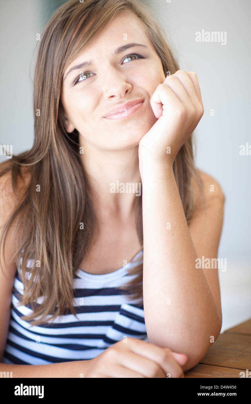 Teenage girl thinking with chin in hand Stock Photo - Alamy