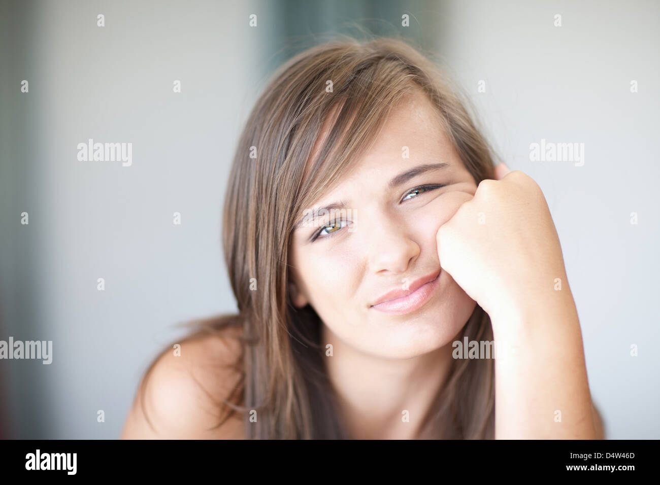 Teenage girl resting cheek on hand Stock Photo - Alamy