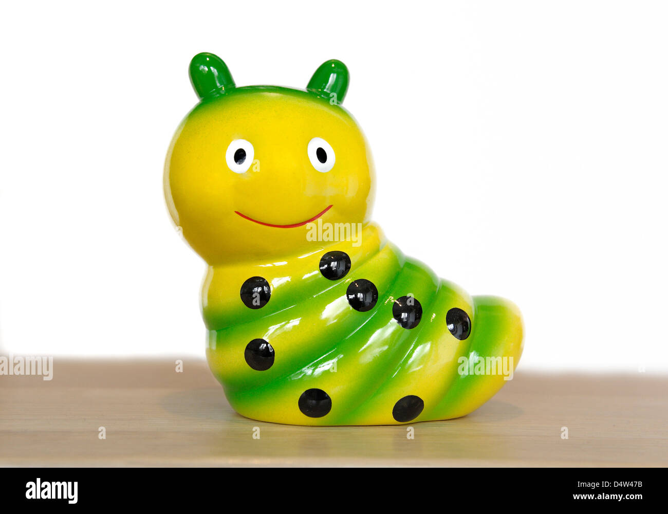 green and yellow ceramic caterpillar money box Stock Photo - Alamy