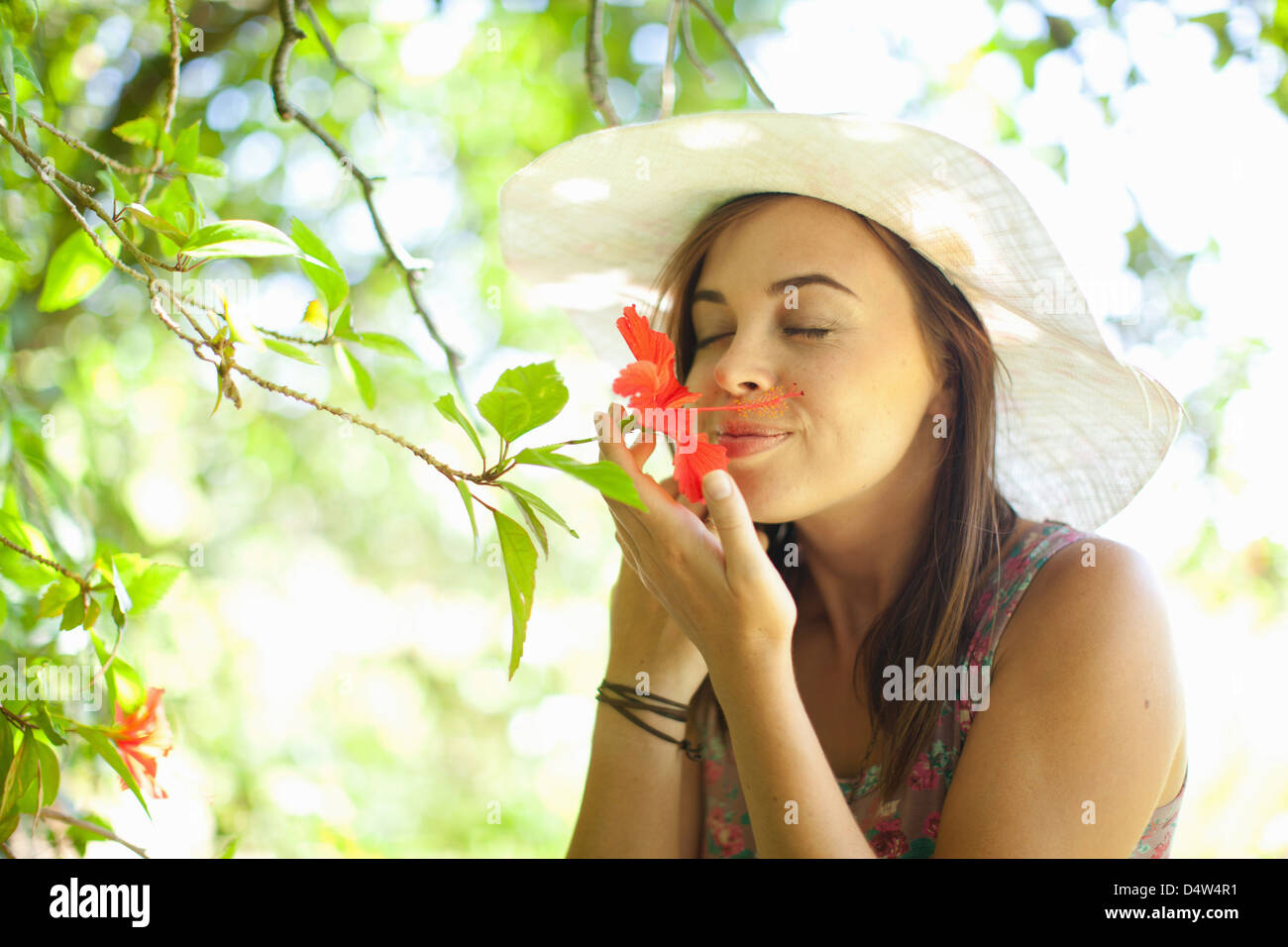 Woman smelling flower in park Stock Photo - Alamy