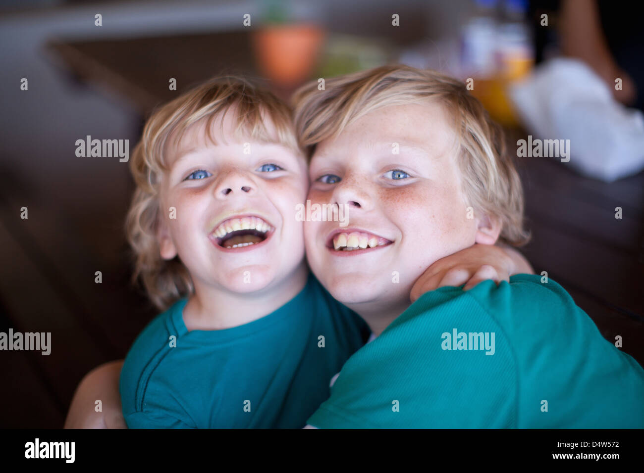 Smiling boys hugging in living room Stock Photo - Alamy