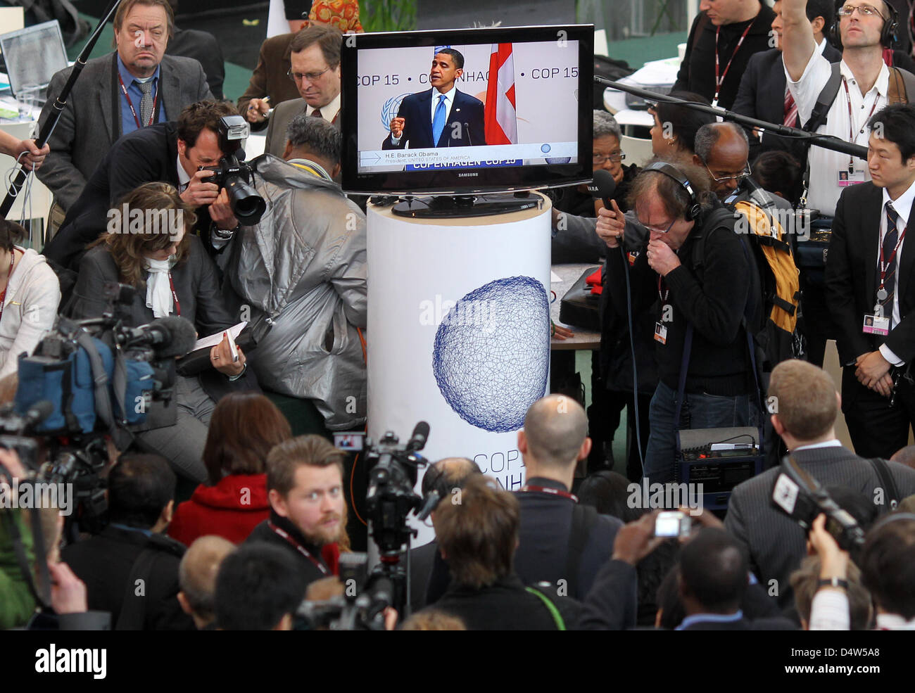 Journalists follow US President Barack Obama's speech on a monitor at ...