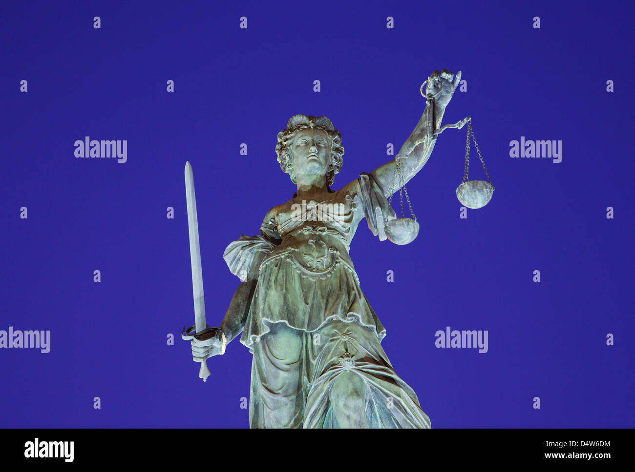 A statue of Justice with its obligatory sword and scales seen in front ...