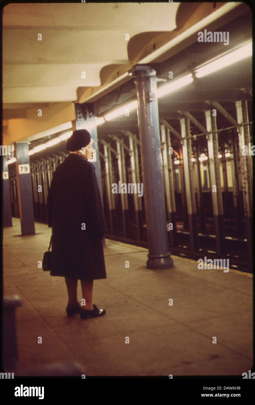 A woman waits for a train at the 79th Street Station in New York City ...