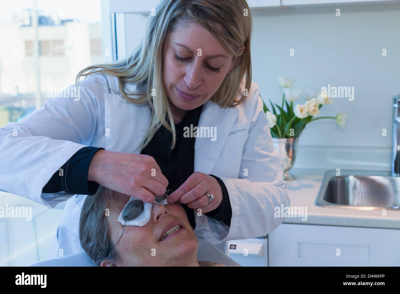 Doctor placing patches on patient's eyes Stock Photo - Alamy
