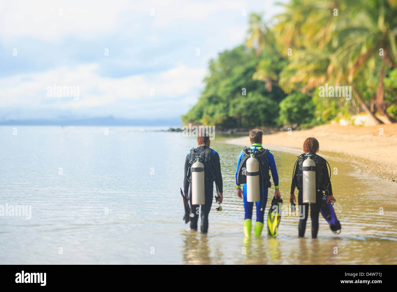 Scuba divers walking on tropical beach Stock Photo - Alamy