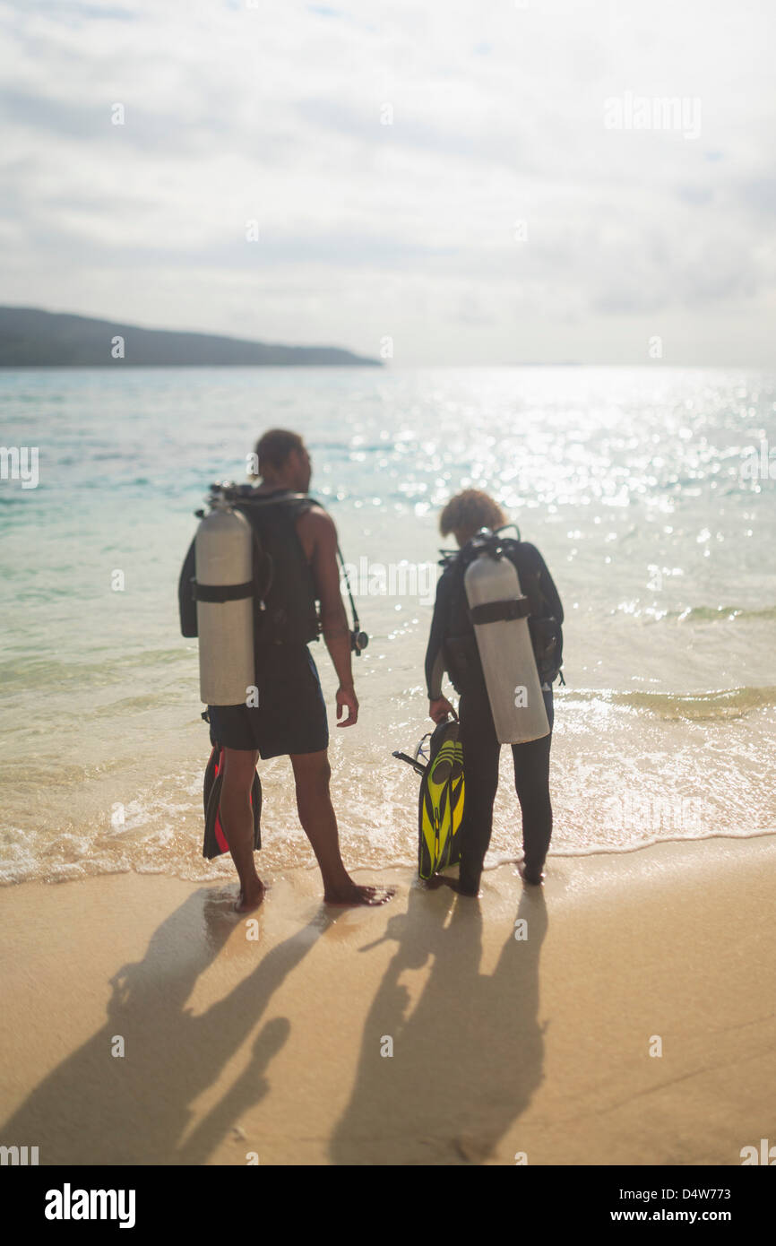 Scuba divers walking on tropical beach Stock Photo - Alamy