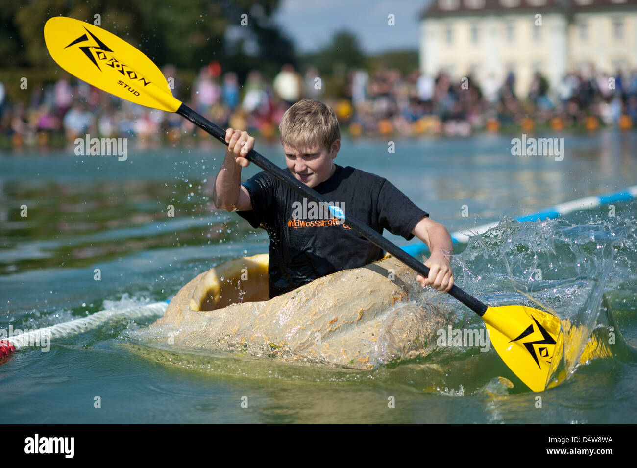 A participant of the pumpkin regatta paddles in a hollowed pumpkin in ...