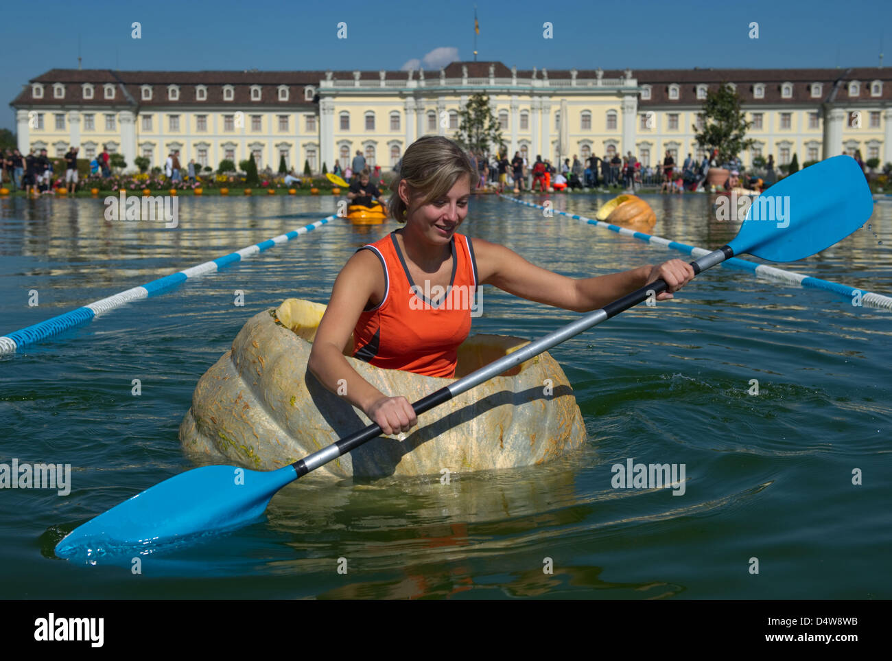 A participant of the pumpkin regatta paddles in a hollowed pumpkin in ...