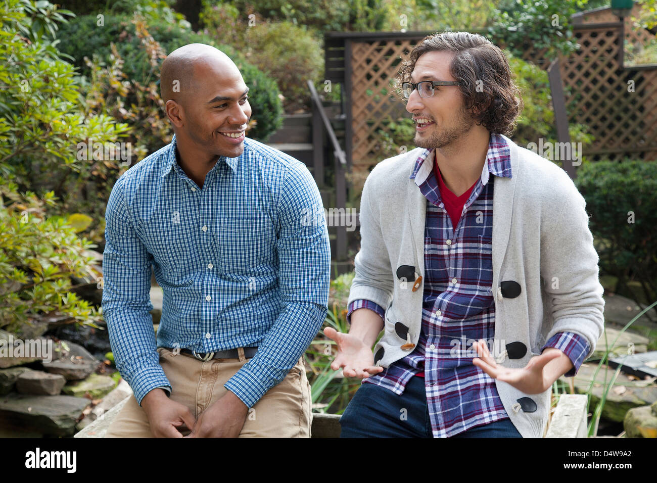 Smiling men talking in backyard Stock Photo - Alamy