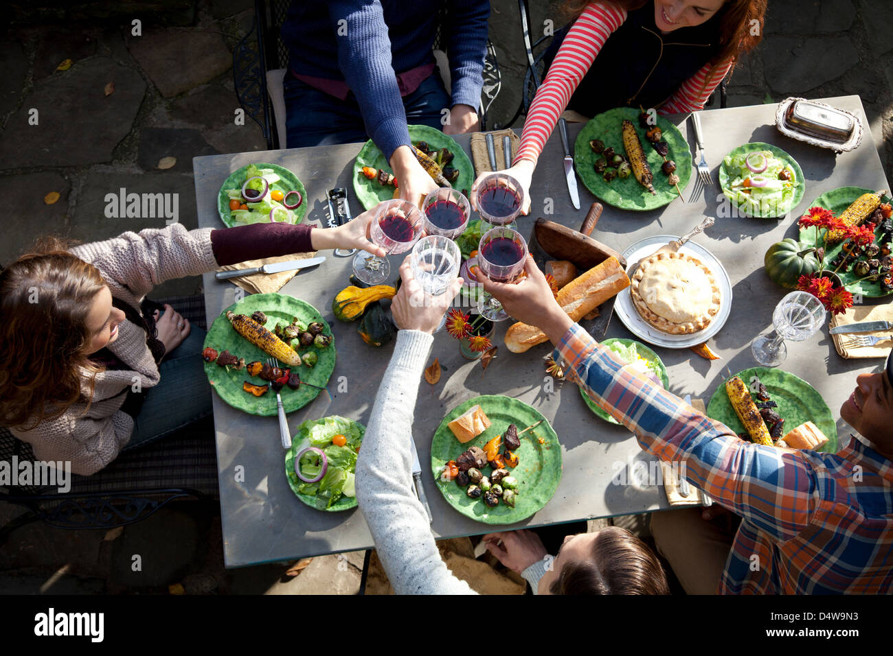 Friends toasting each other at table Stock Photo - Alamy