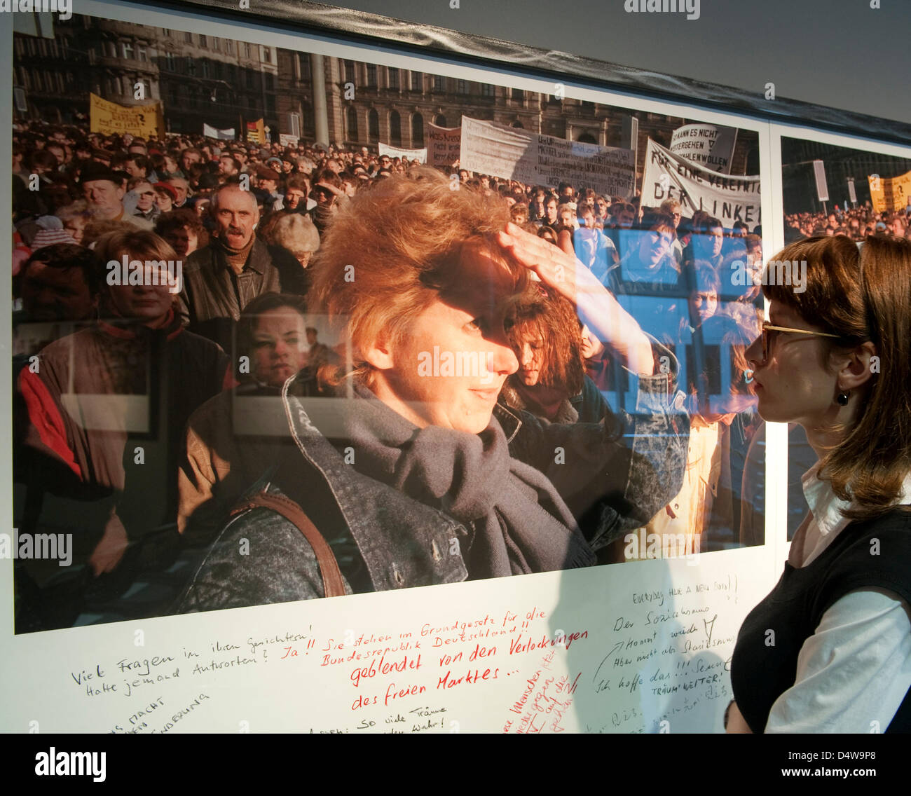 A woman eyes a large photography from the series 'The Fall' by Gilles ...