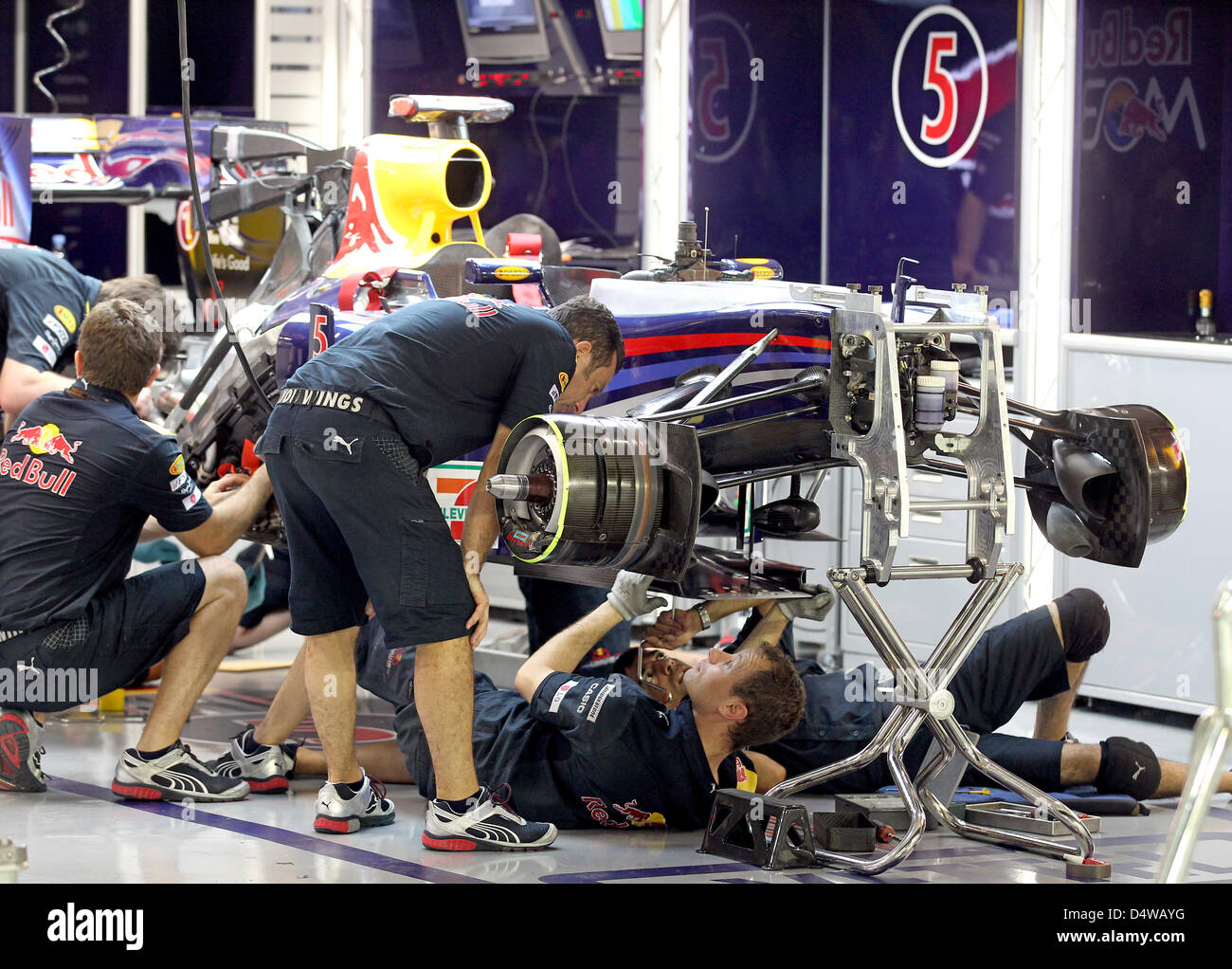 Mechanics work on the racing car of Sebastian Vettel of Red Bull in ...