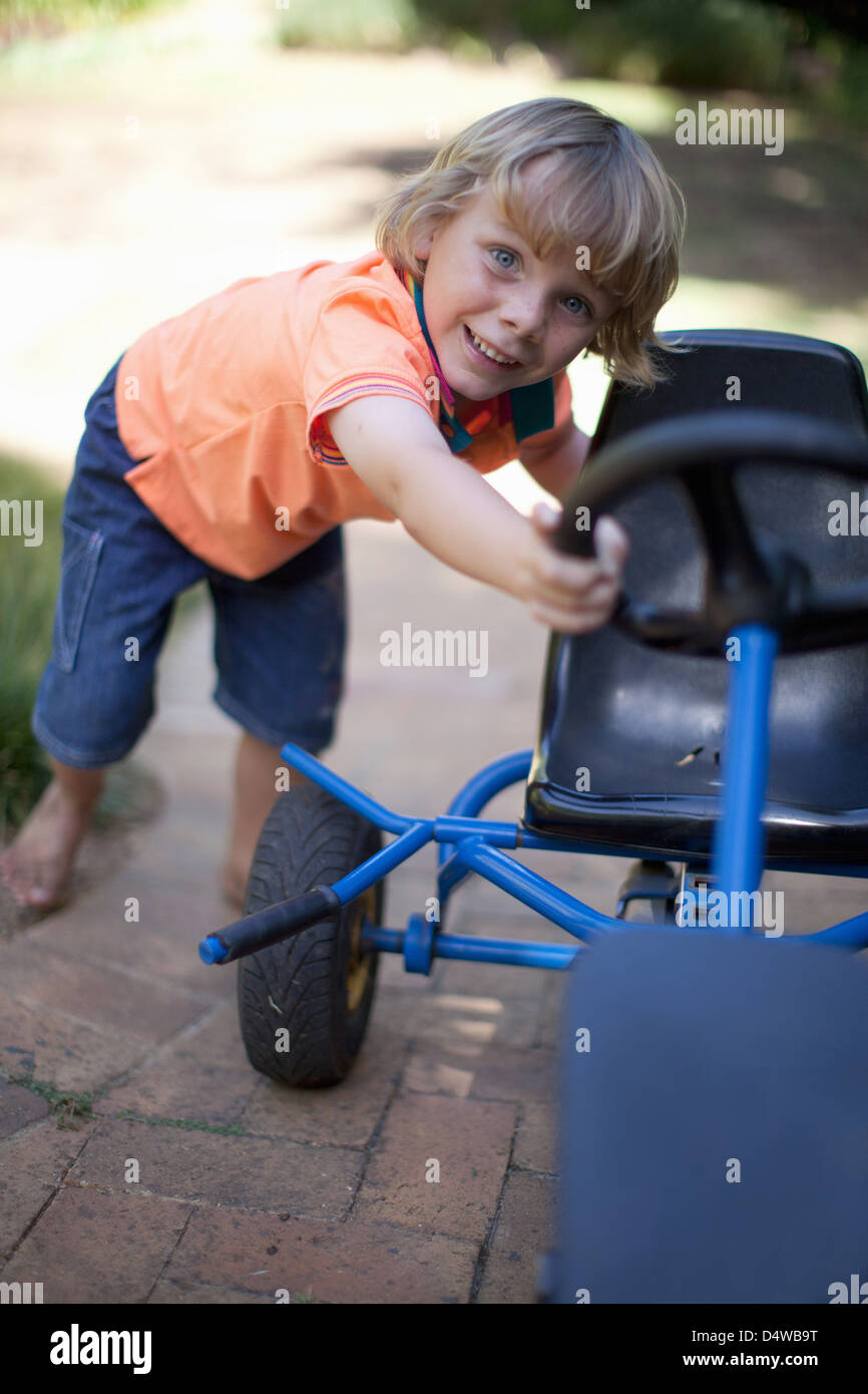 Boy pushing go kart outdoors Stock Photo - Alamy
