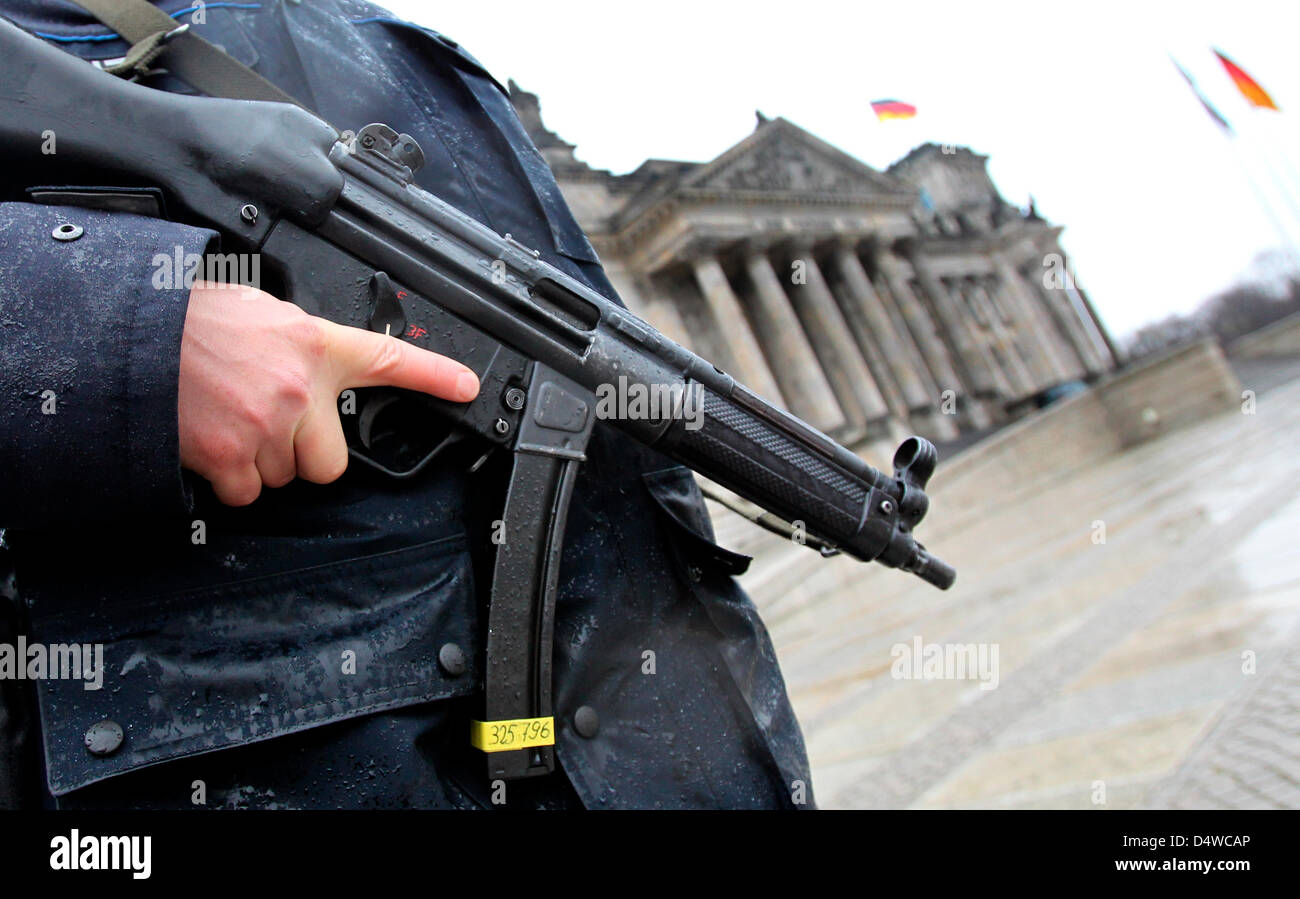 A police officer with machine gun guards the Reichstag building in ...