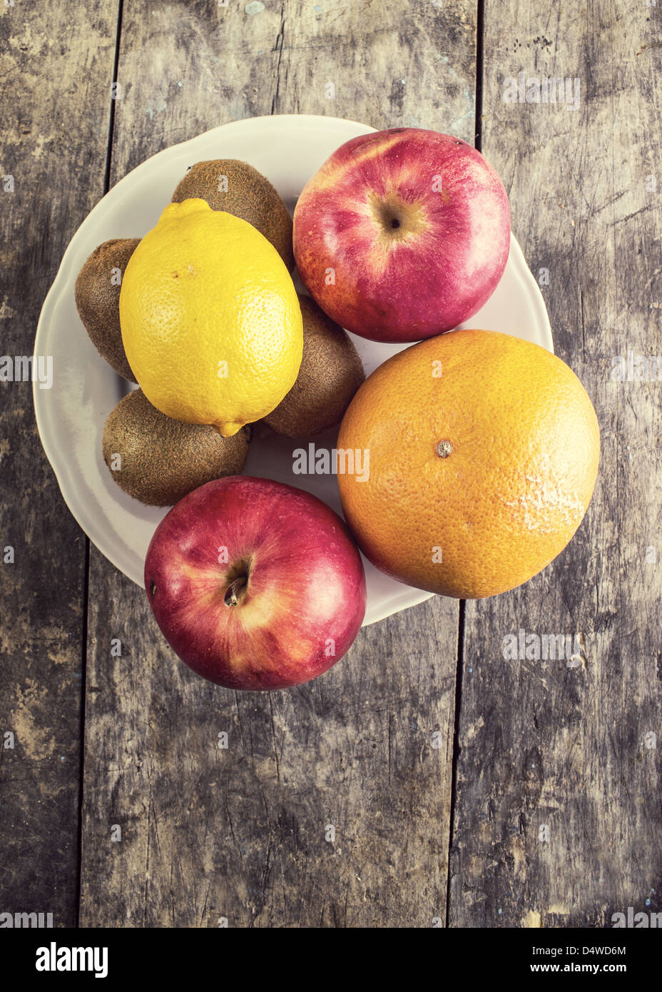Various fruits on a plate on old table,retro Stock Photo - Alamy