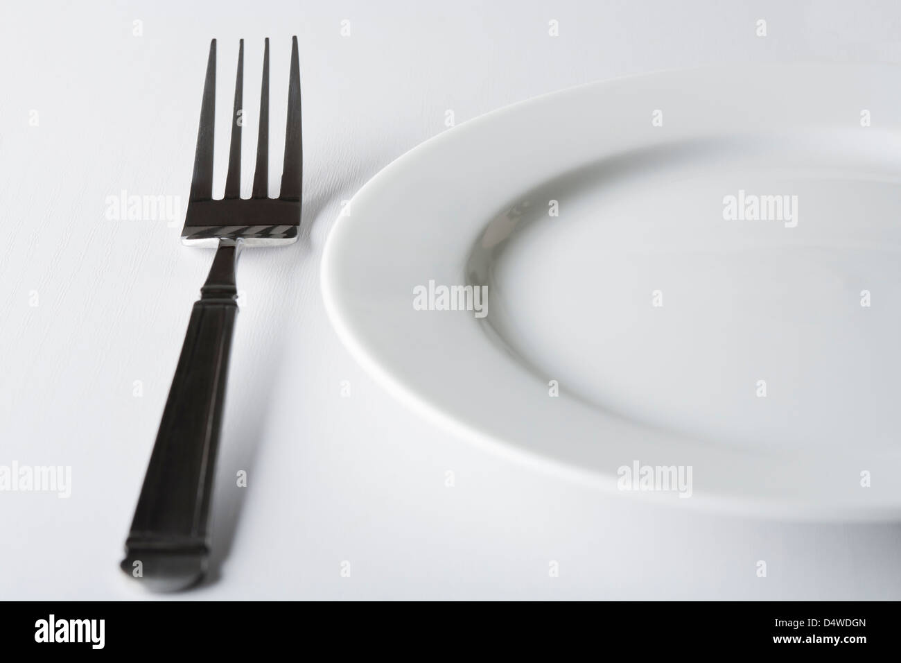 Fork next to plate Stock Photo - Alamy
