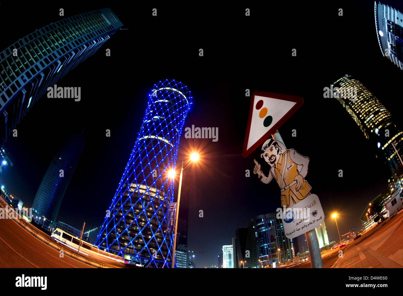 The 'Qipco Tower' is illuminated with blue light between other high ...