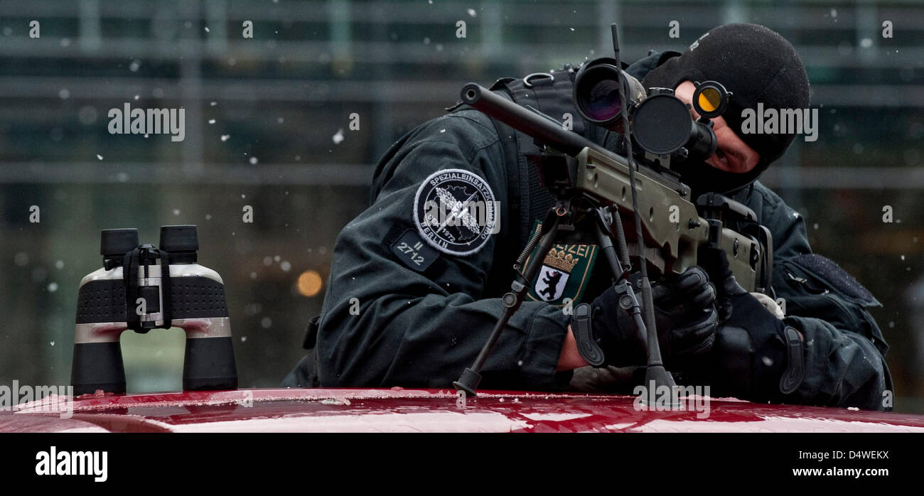 A hooded special police sniper guards the Economy Leadership Meeting ...