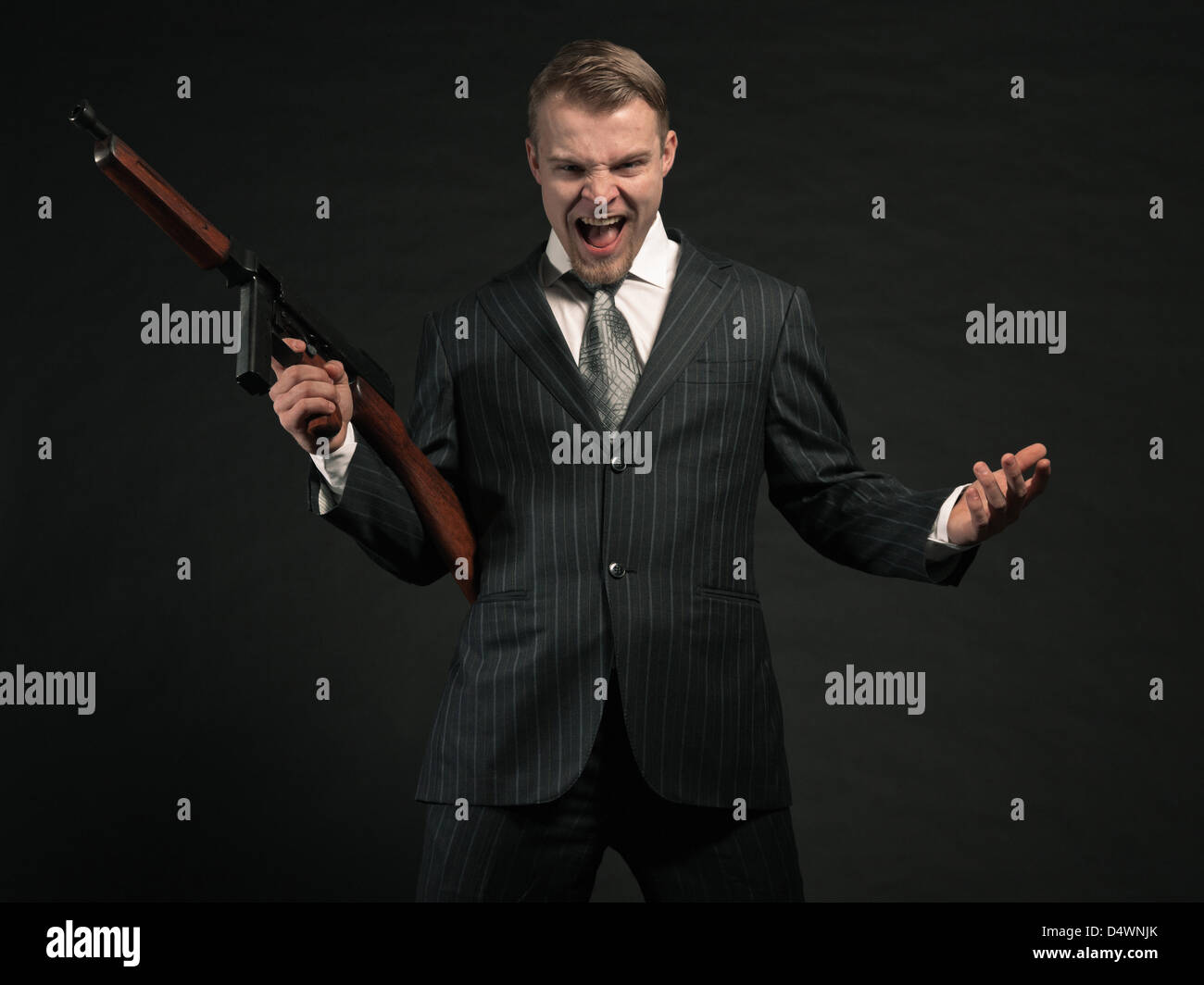 Man in suit shooting with rifle. Studio shot against black Stock Photo ...