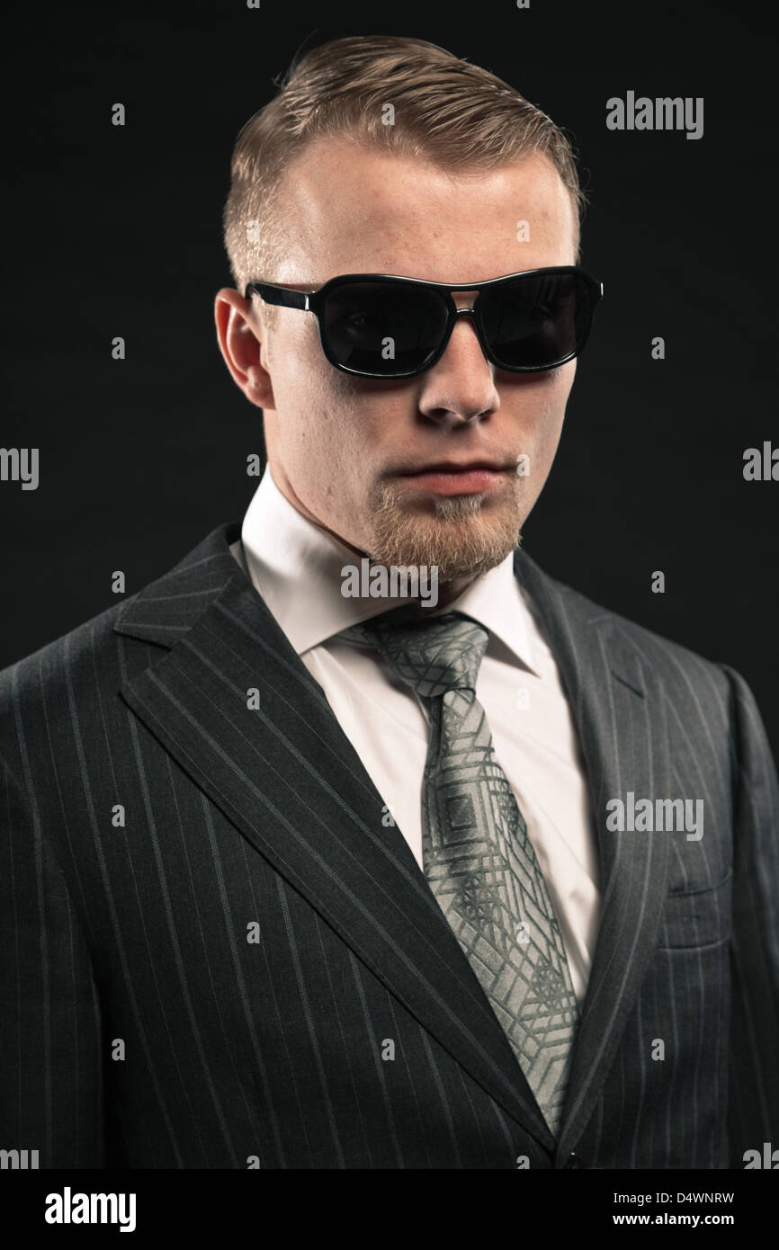 Fashion man in suit wearing sunglasses. Studio shot Stock Photo - Alamy