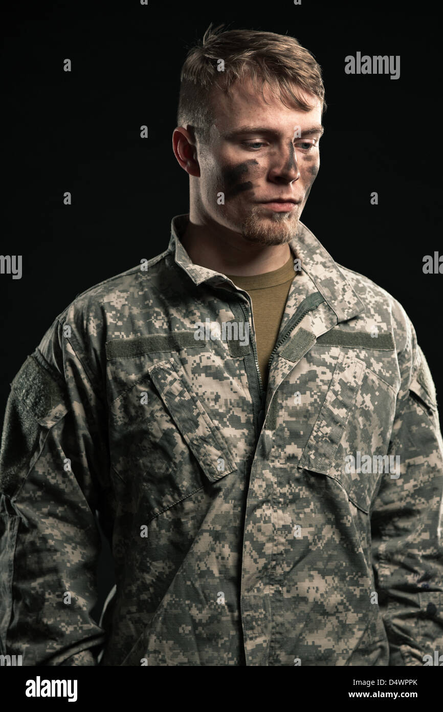 Military young man with camouflage on face. Studio shot Stock Photo - Alamy